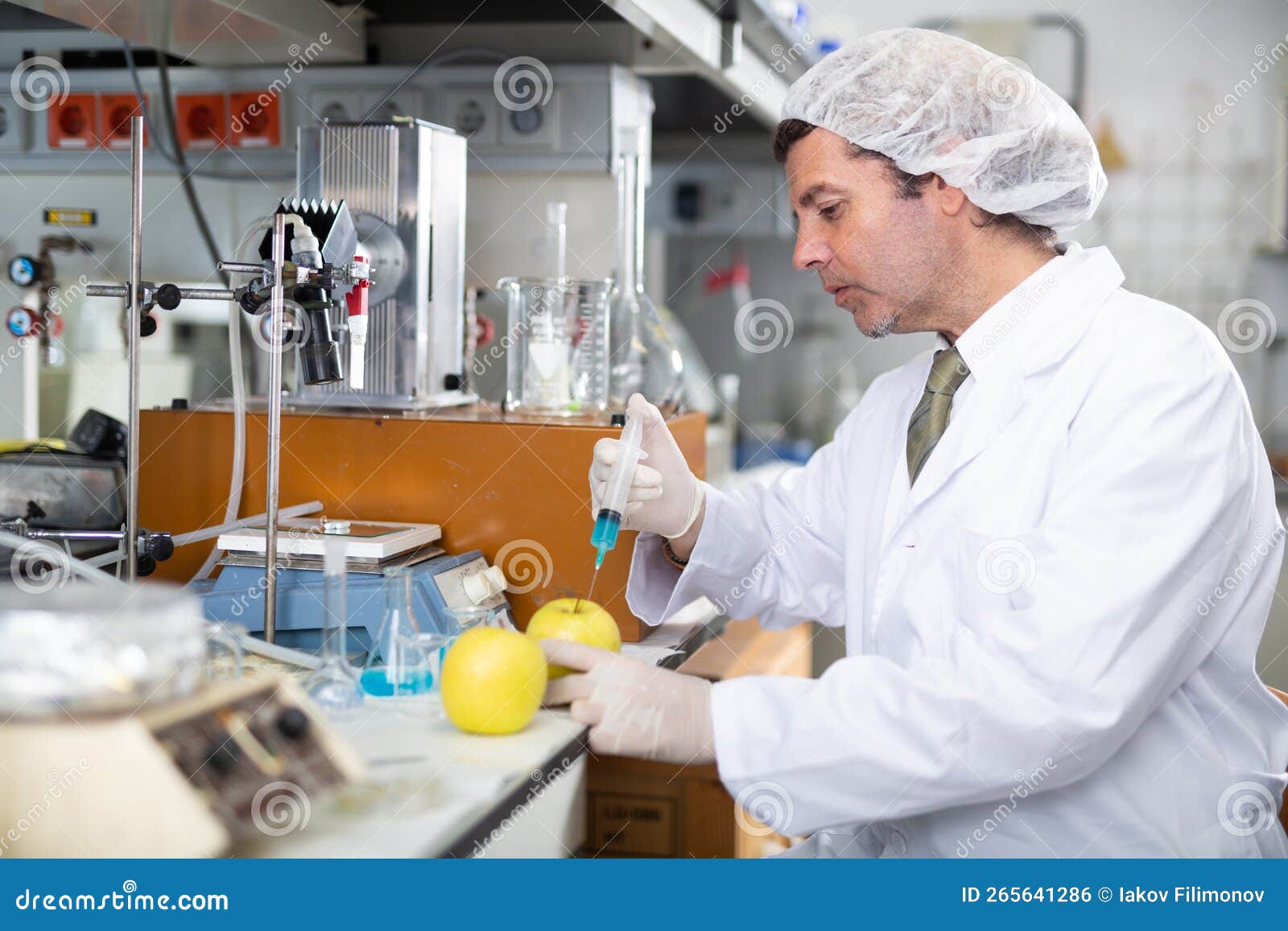 Geneticist Working in Laboratory, Injecting Additives into Apple during ...