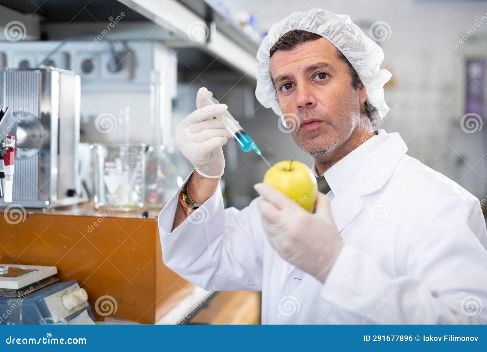 Geneticist Working in Laboratory, Injecting Additives into Apple during ...
