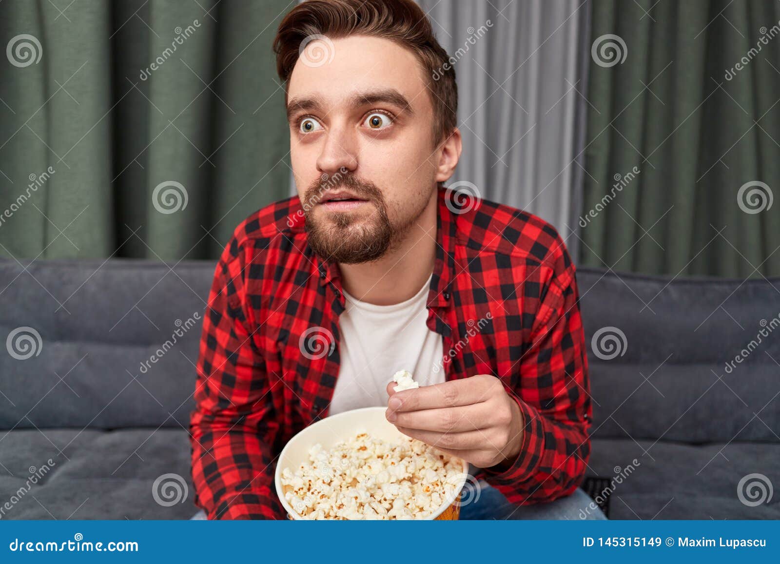 Geschokte Mens Die Popcorn Eten En Op Film Letten Stock Afbeelding