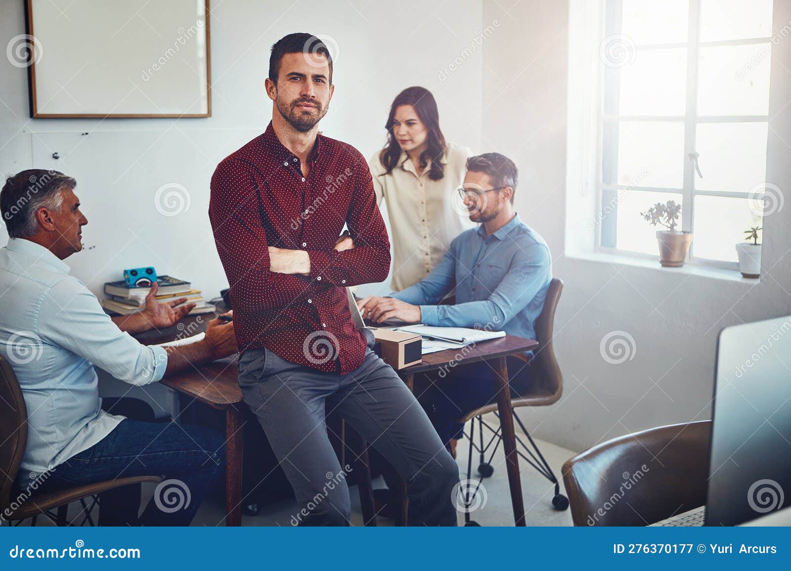 We always Get the Work Done. Portrait of a Young Man Sitting on a Desk ...