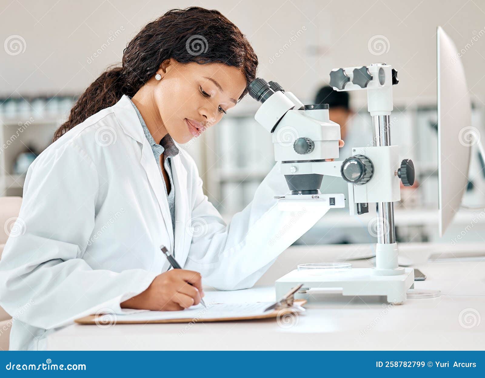 Getting Ahead on Her Findings. a Young Scientist Writing Notes while ...