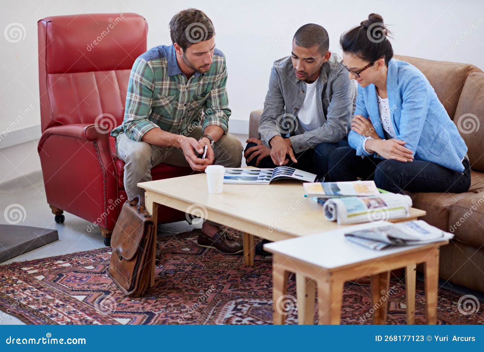 Getting Down To Designing. a Group of Designers Having a Meeting Around ...