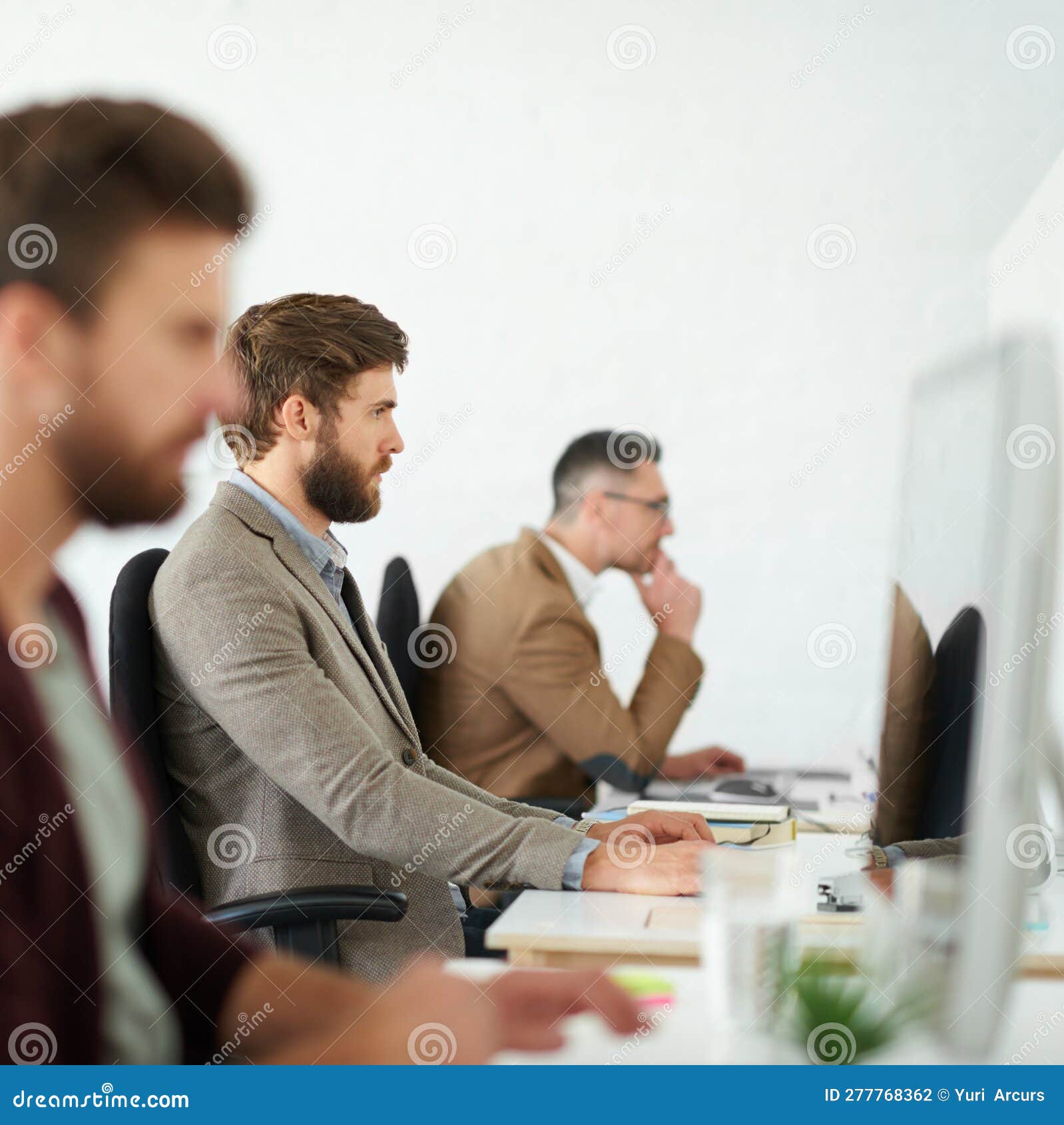 Getting Down To Work. Low Angle Shot of a Row of Creative Professionals ...