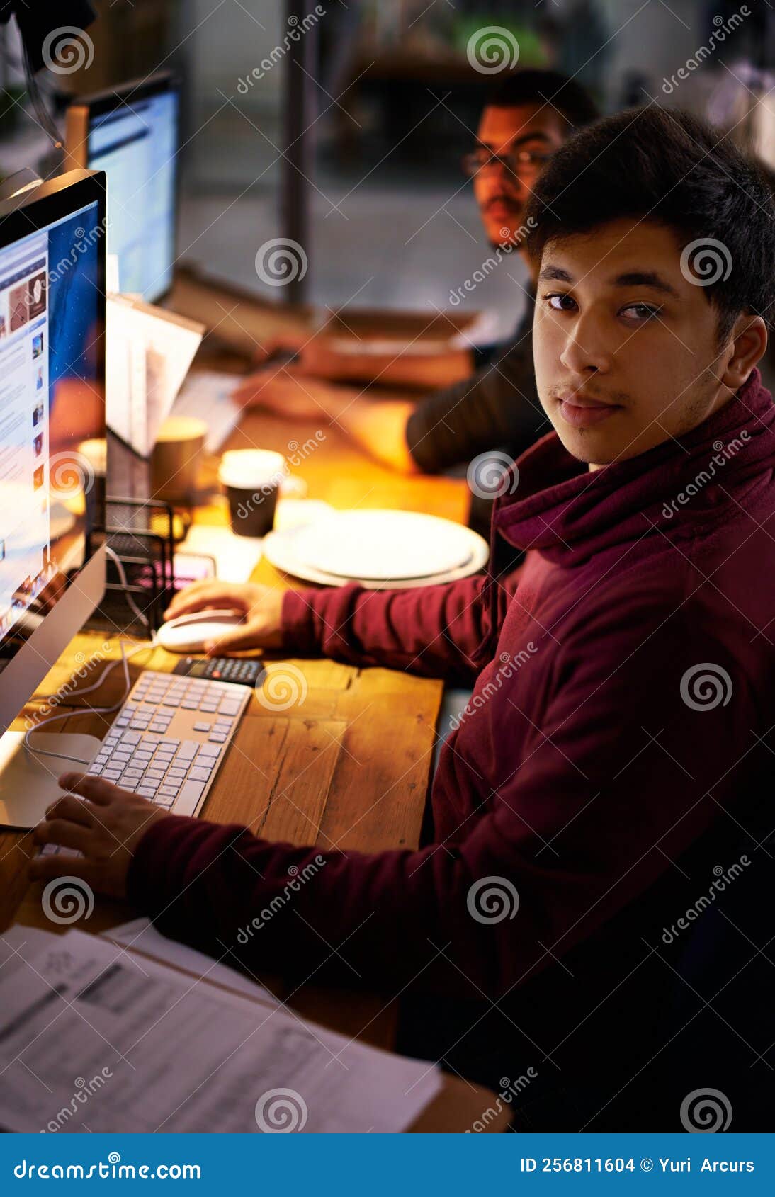 Getting the Job Done. a Group of Young Coworkers Working in a Dimly-lit ...