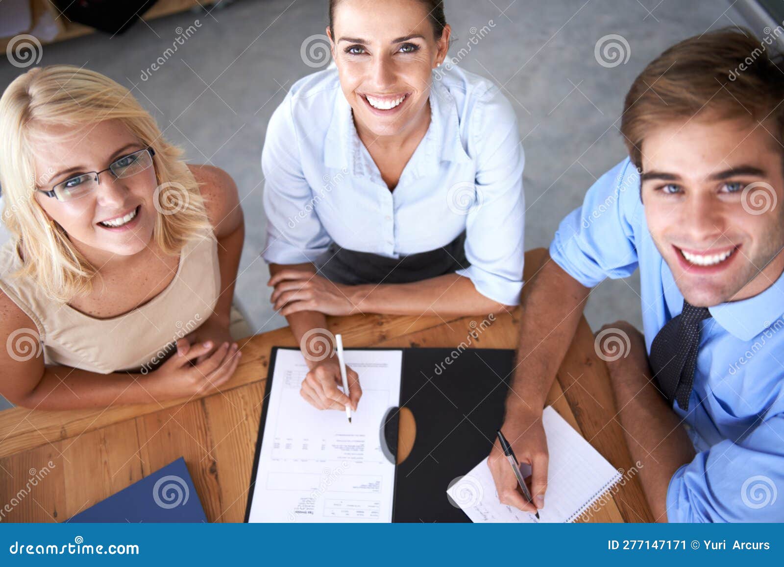 Getting My Teams Input. Three Young Executives Sitting Around a Table ...