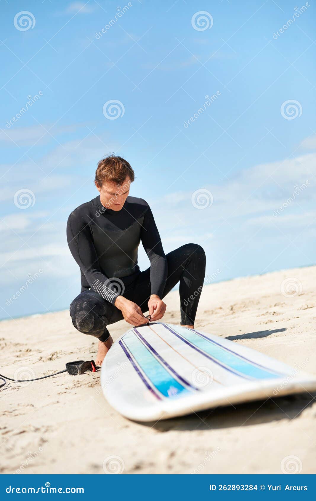 Getting Ready for a Surf. a Handsome Surfer Sitting on the Beach Making ...