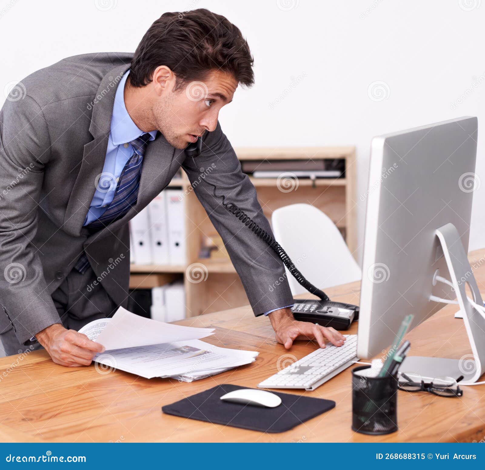 Getting Work Done. a Handsome Businessman Multitasking at His Desk ...