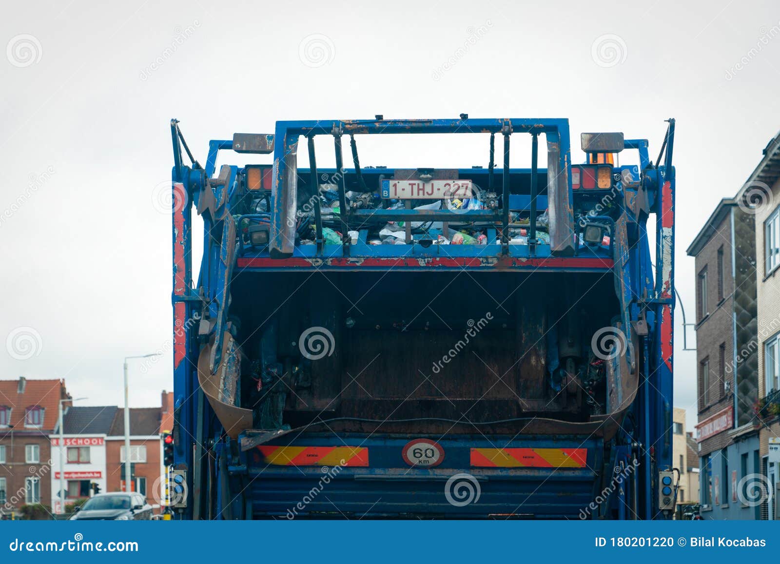 View On Red Garbage Truck With Hydraulic Arms Lifting A Heavy Rubbish ...