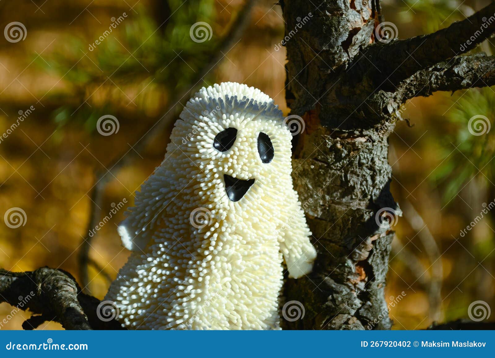 A Ghost Toy Stands on a Branch Leaning on a Tree Trunk in the Forest ...