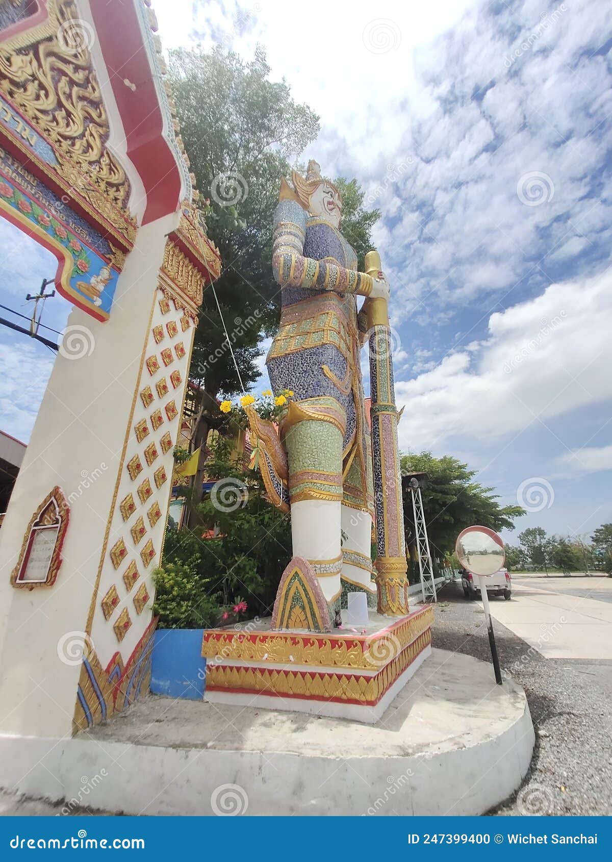 A Giant Statue Stands Holding a Cylinder in Front of the Entrance ...