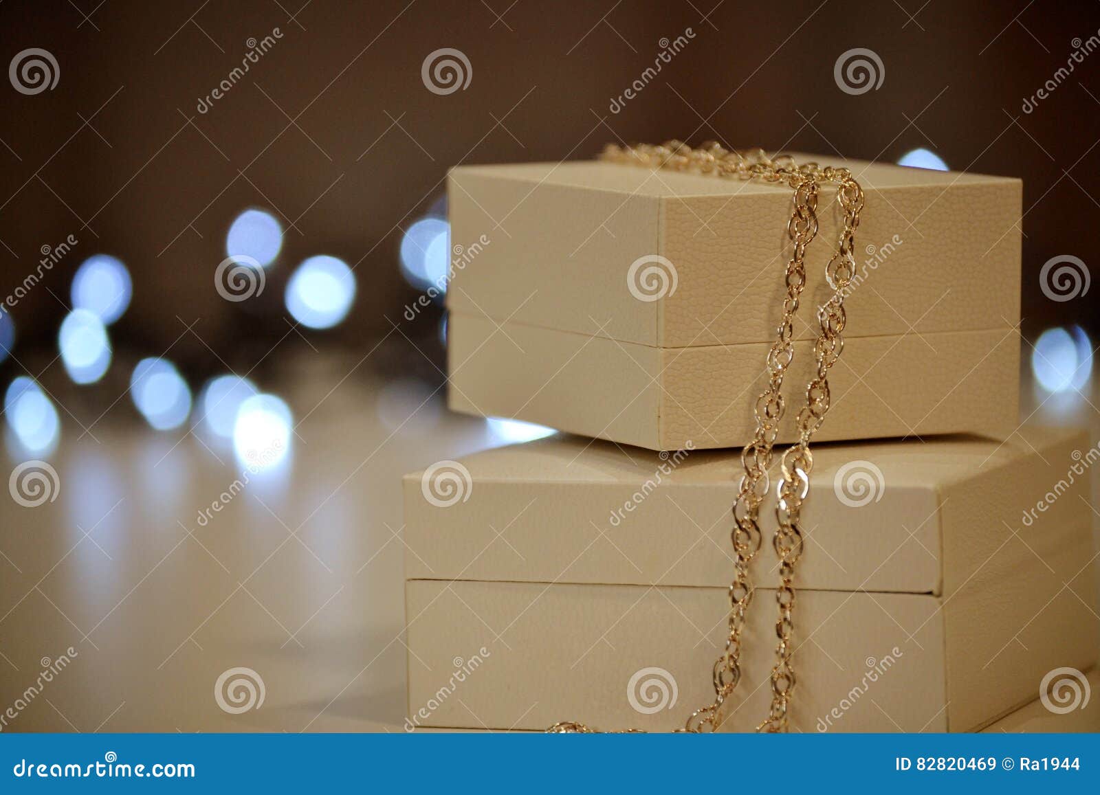 Gift Box with a Gold Chain on a Background of Lights Stock Image ...