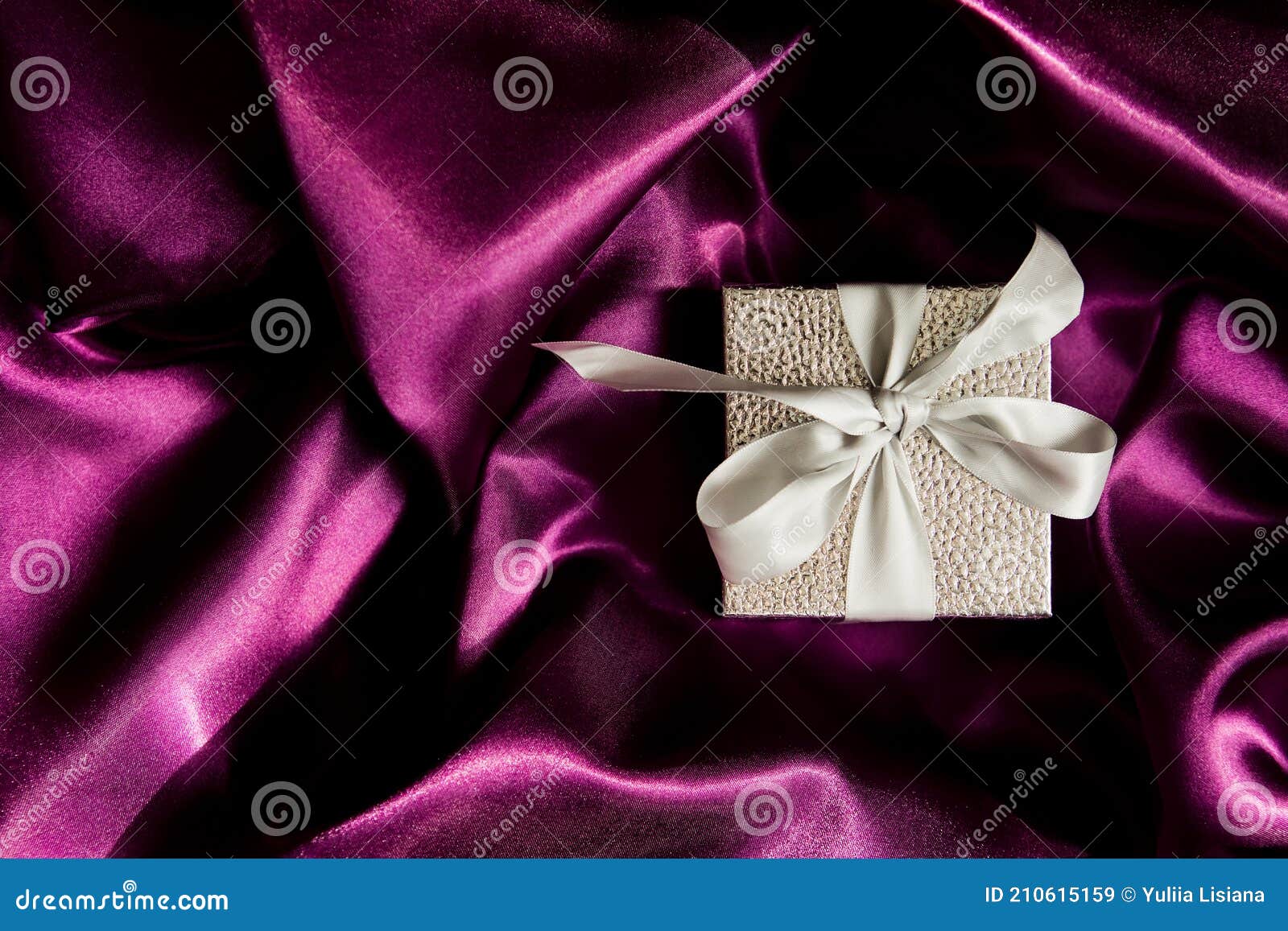 Gift Box with Silver Ribbon on Purple Satin Fabric Stock Image - Image ...