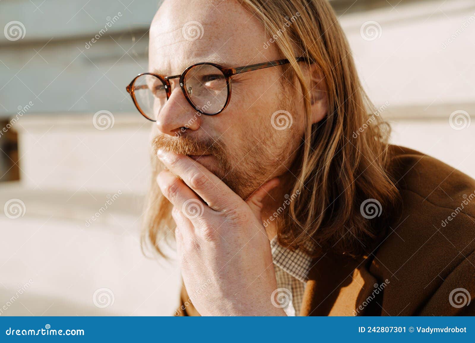 Ginger Man Wearing Eyeglasses Looking Aside while Sitting on Stairs ...