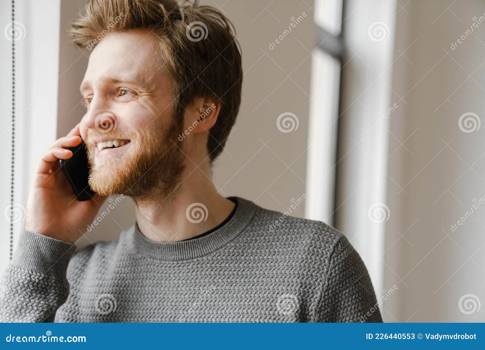 Ginger Young Man Talking on Mobile Phone while Standing Stock Image ...