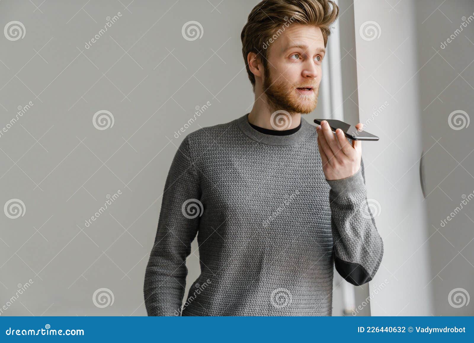 Ginger Young Man Talking on Mobile Phone while Standing Stock Photo ...