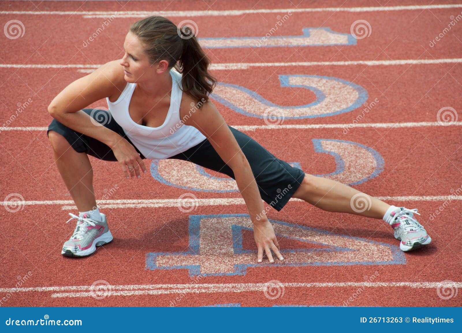 Giovane Donna Che Allunga Sulla Pista Corrente Immagine Stock ...