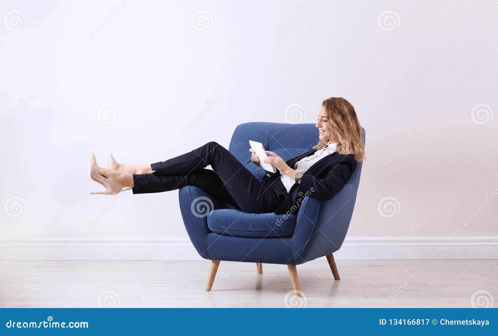 Giovane Donna Con La Compressa in Poltrona Immagine Stock - Immagine di ...