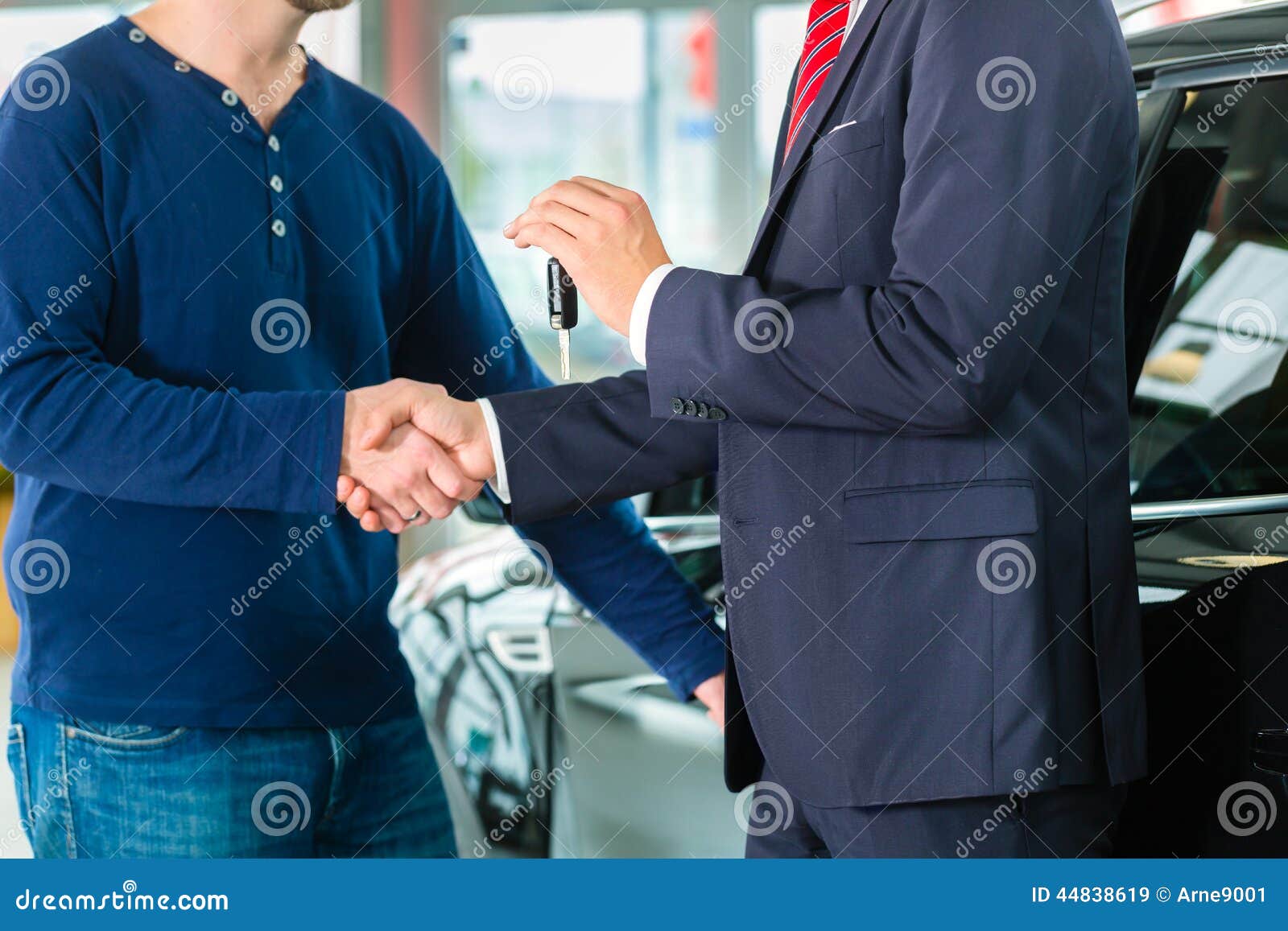 Giovane E Venditore Con L'auto Nel Concessionario Auto Immagine Stock ...