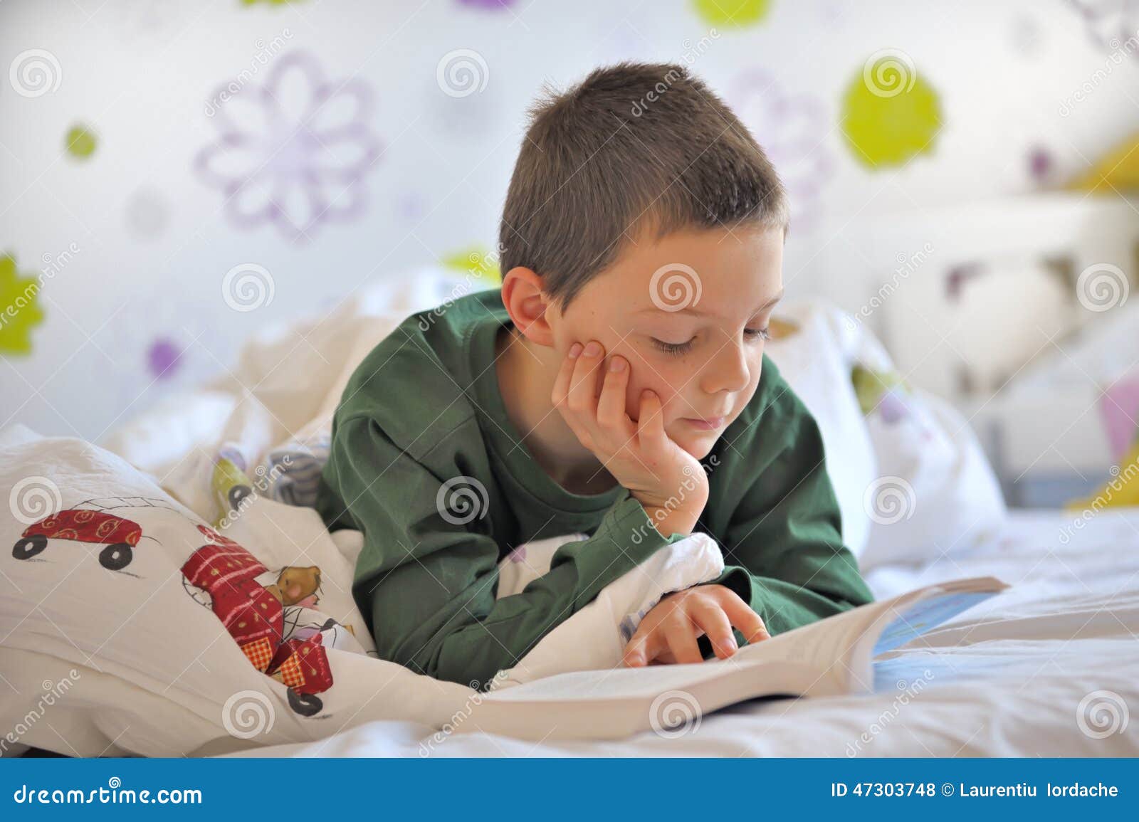 Giovane Ragazzo Che Legge Un Libro a Letto Fotografia Stock - Immagine ...