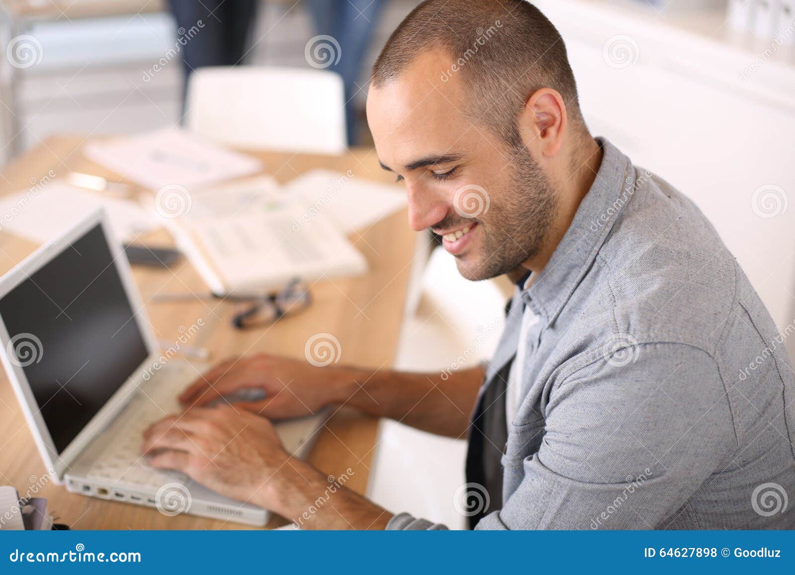 Giovane Sorridente All'ufficio Che Lavora Al Computer Portatile ...