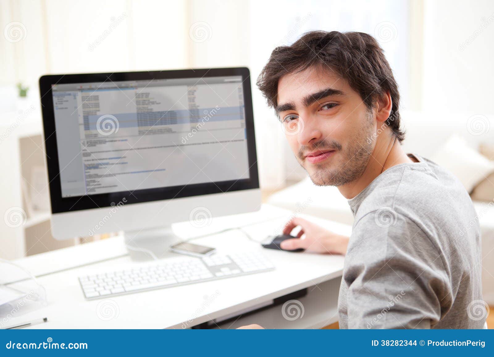 Giovane Uomo Sorridente Davanti Al Computer Fotografia Stock - Immagine ...