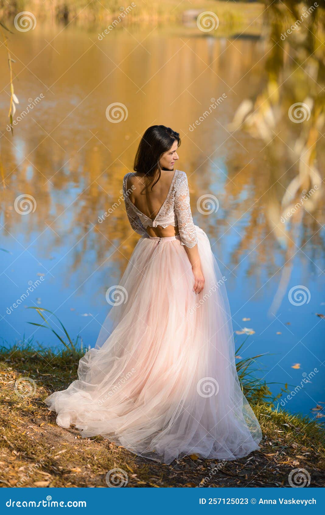Girl In A Beautiful Light Puffy Dress On The Shore Of A Pond With Blue Water Stock Image Image