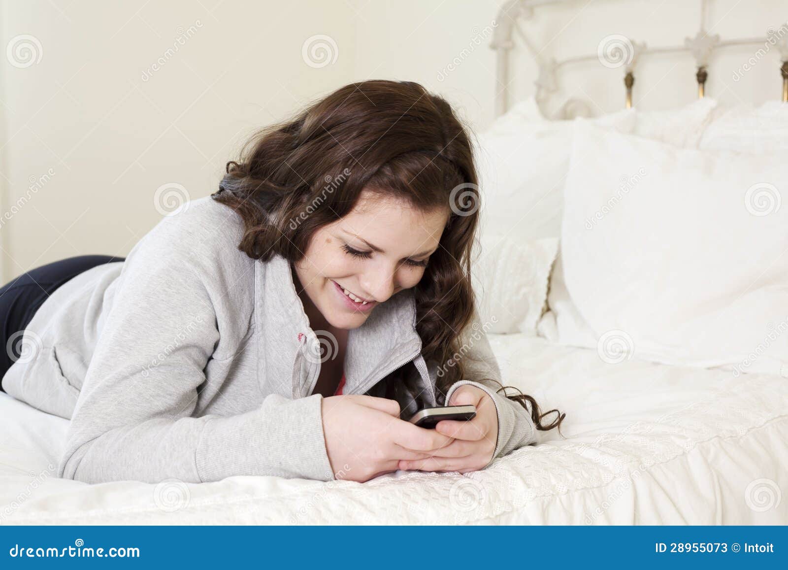 Girl on Bed Texting stock image. Image of female, attractive - 28955073