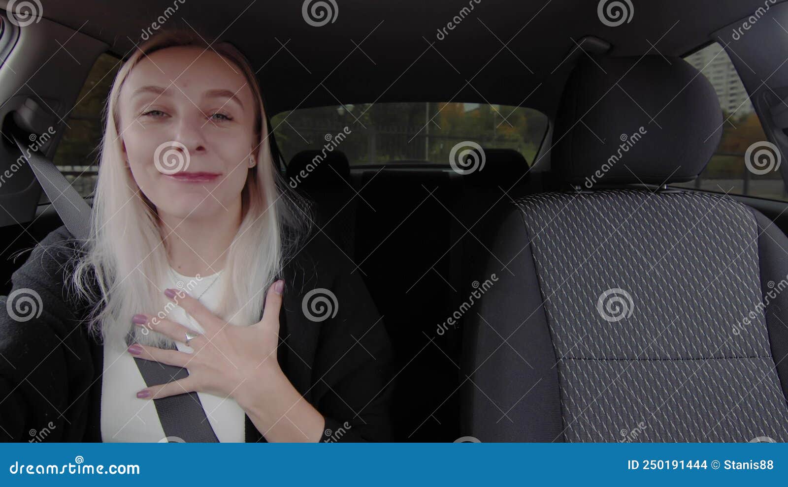 The Girl Behind The Wheel Of The Car Looks At The Camera People Are