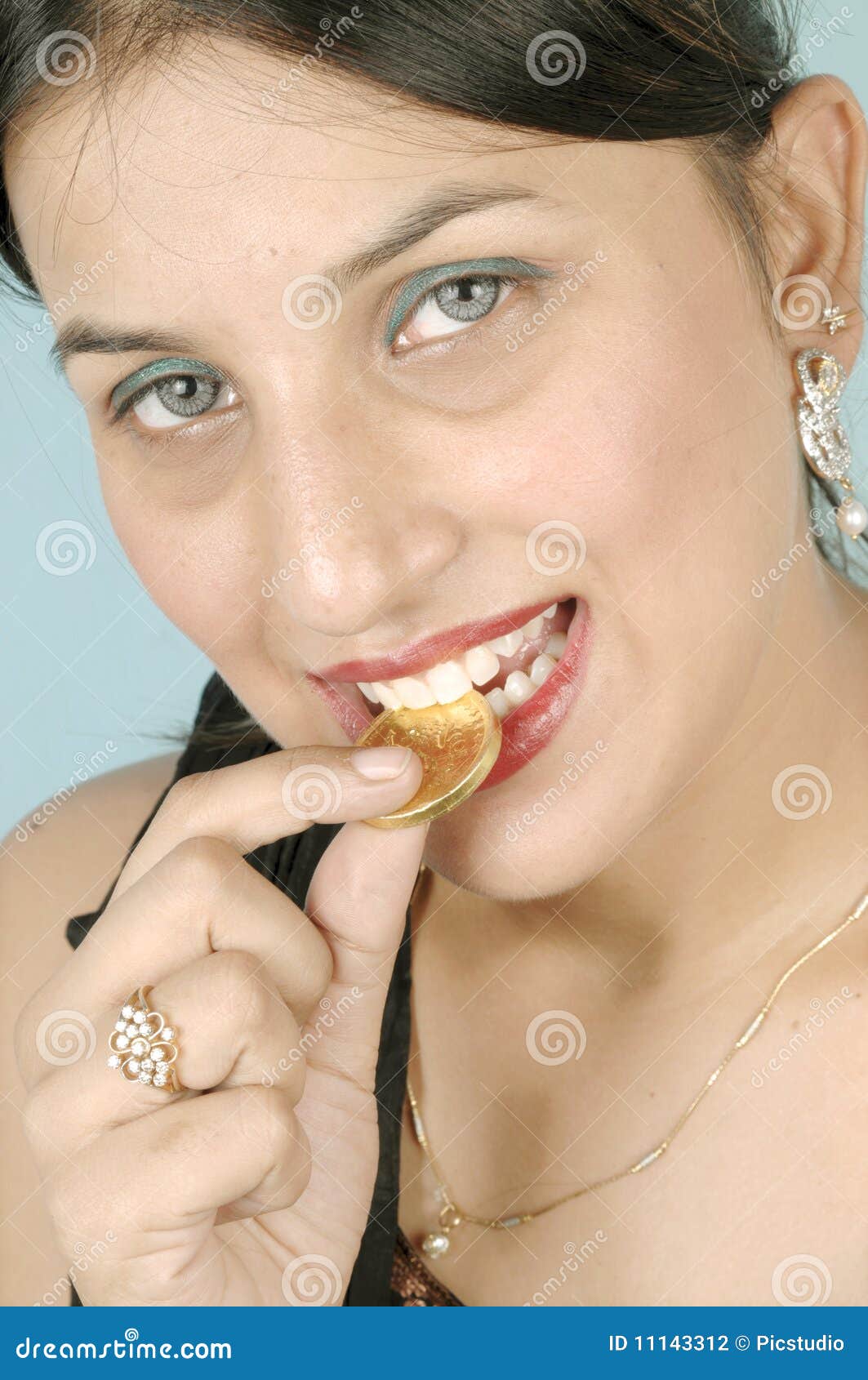 Girl biting gold coin stock photo. Image of currency - 11143312