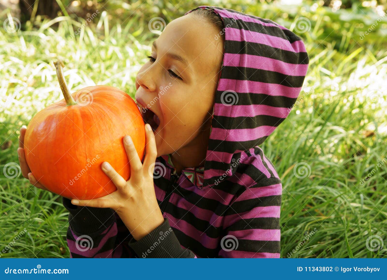 Girl biting pumpkin stock photo. Image of cheerful, grass - 11343802