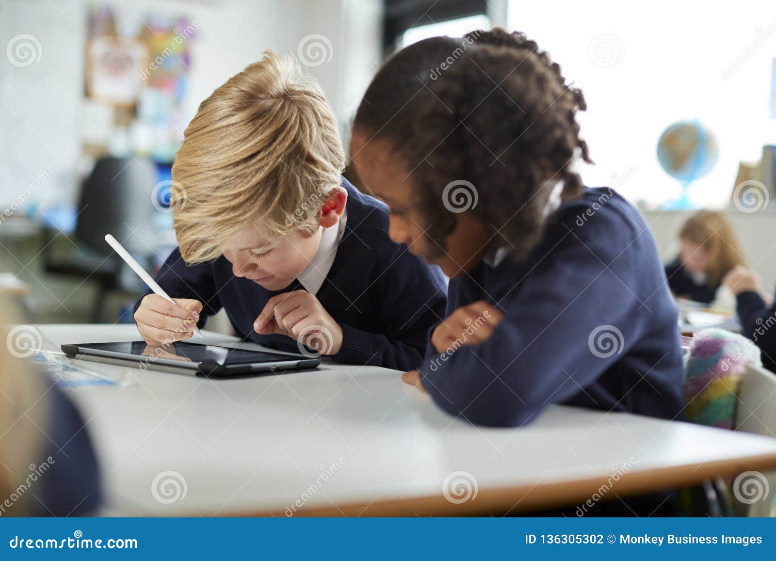 A Girl and a Boy Using a Tablet Computer and Stylus in a Primary School ...