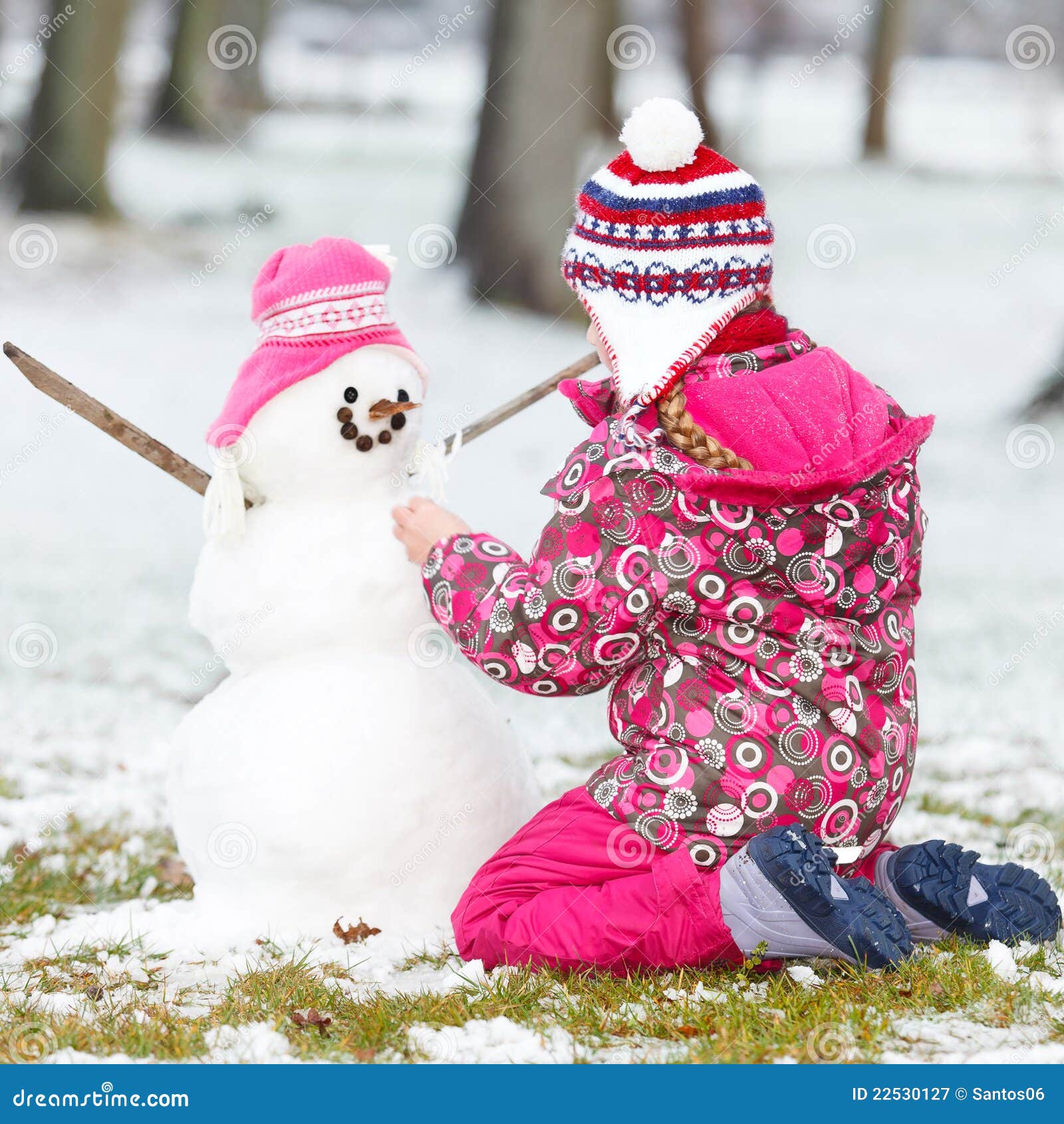 Girl building a snowman stock image. Image of snowsuit - 22530127
