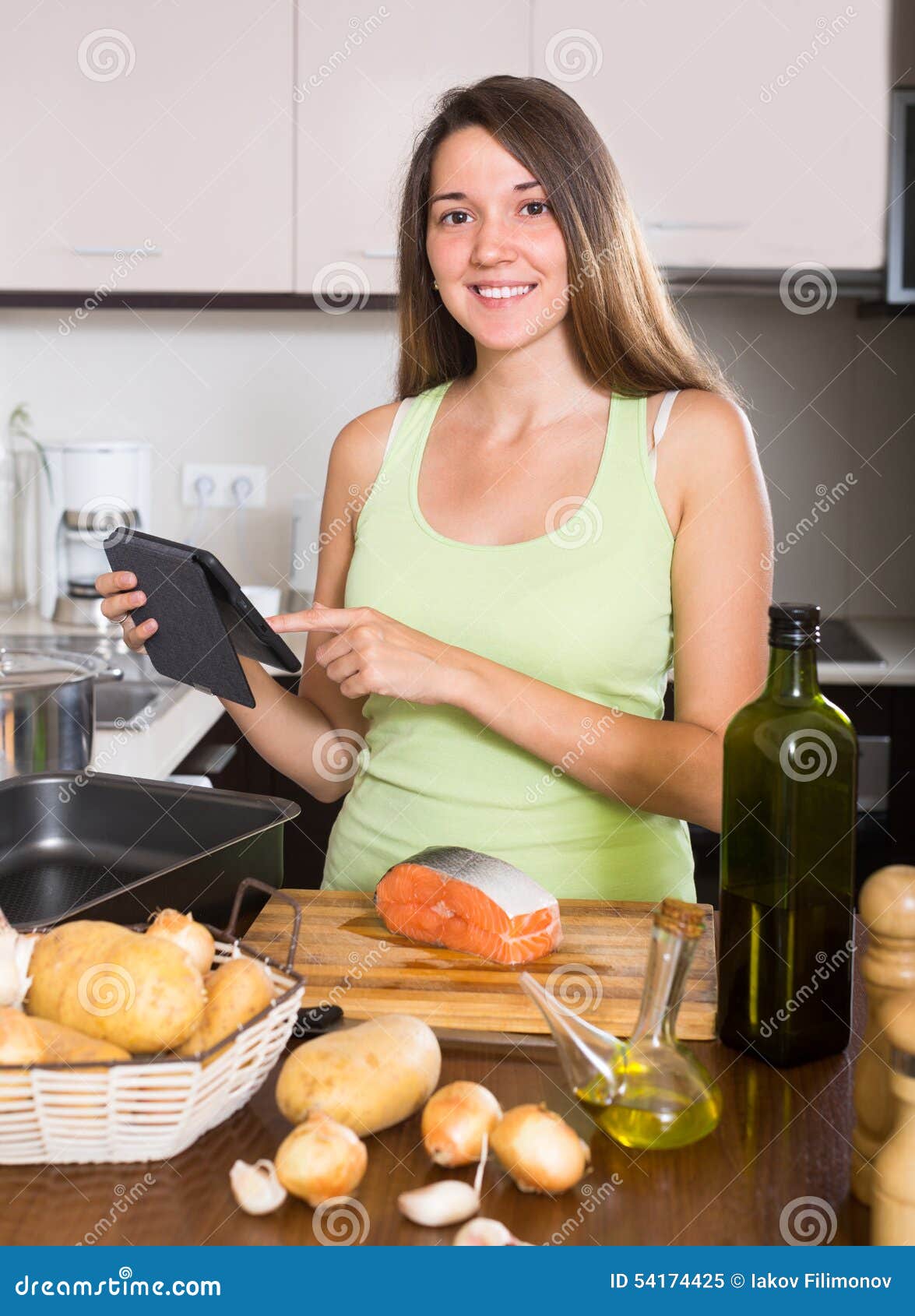 Girl Cooking Salmon Fish and Reading Ereader Stock Image - Image of ...