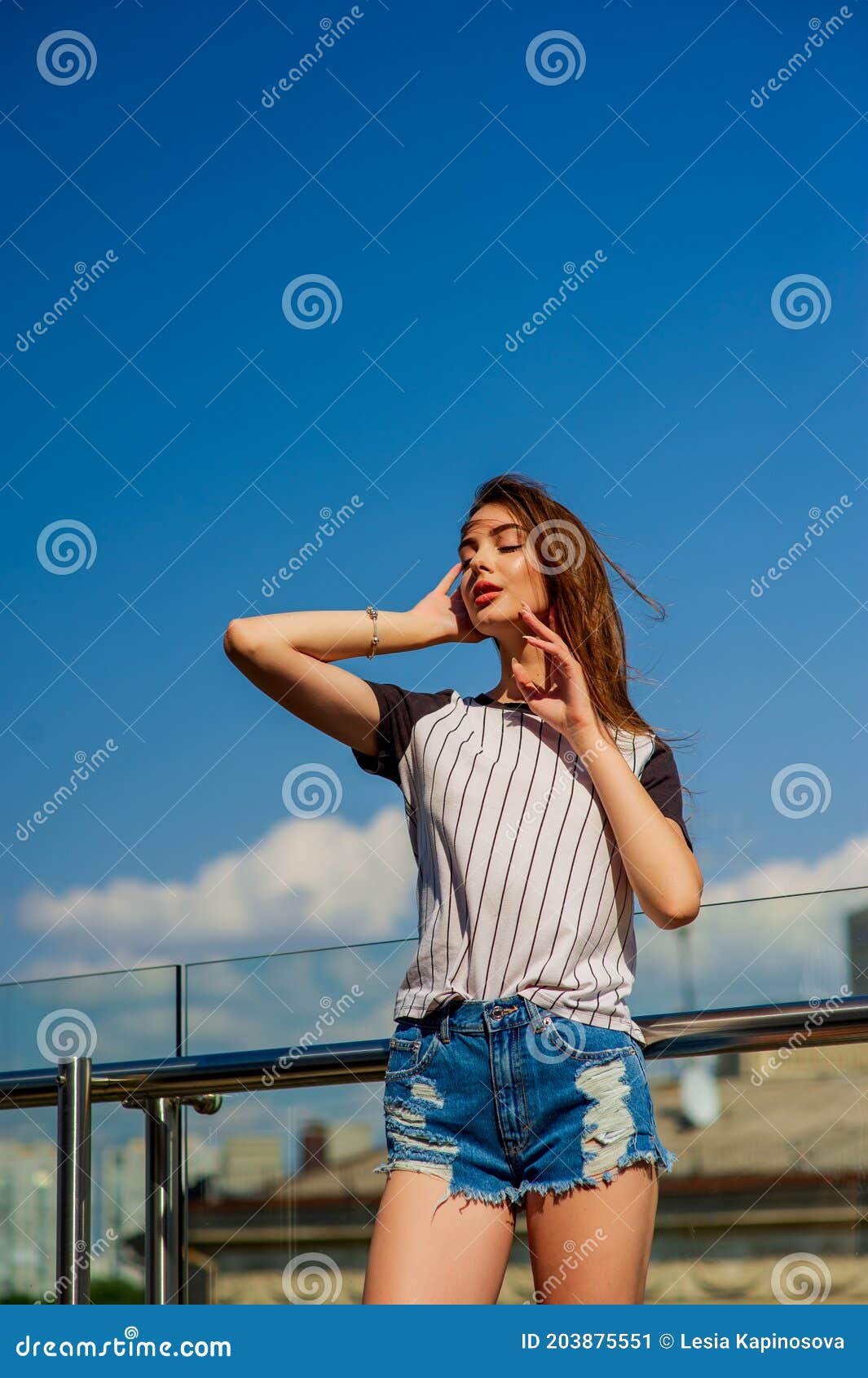 Girl In Denim Shorts On The Balcony Mini Denim Shorts Woman In A Striped Shirt Stock Image