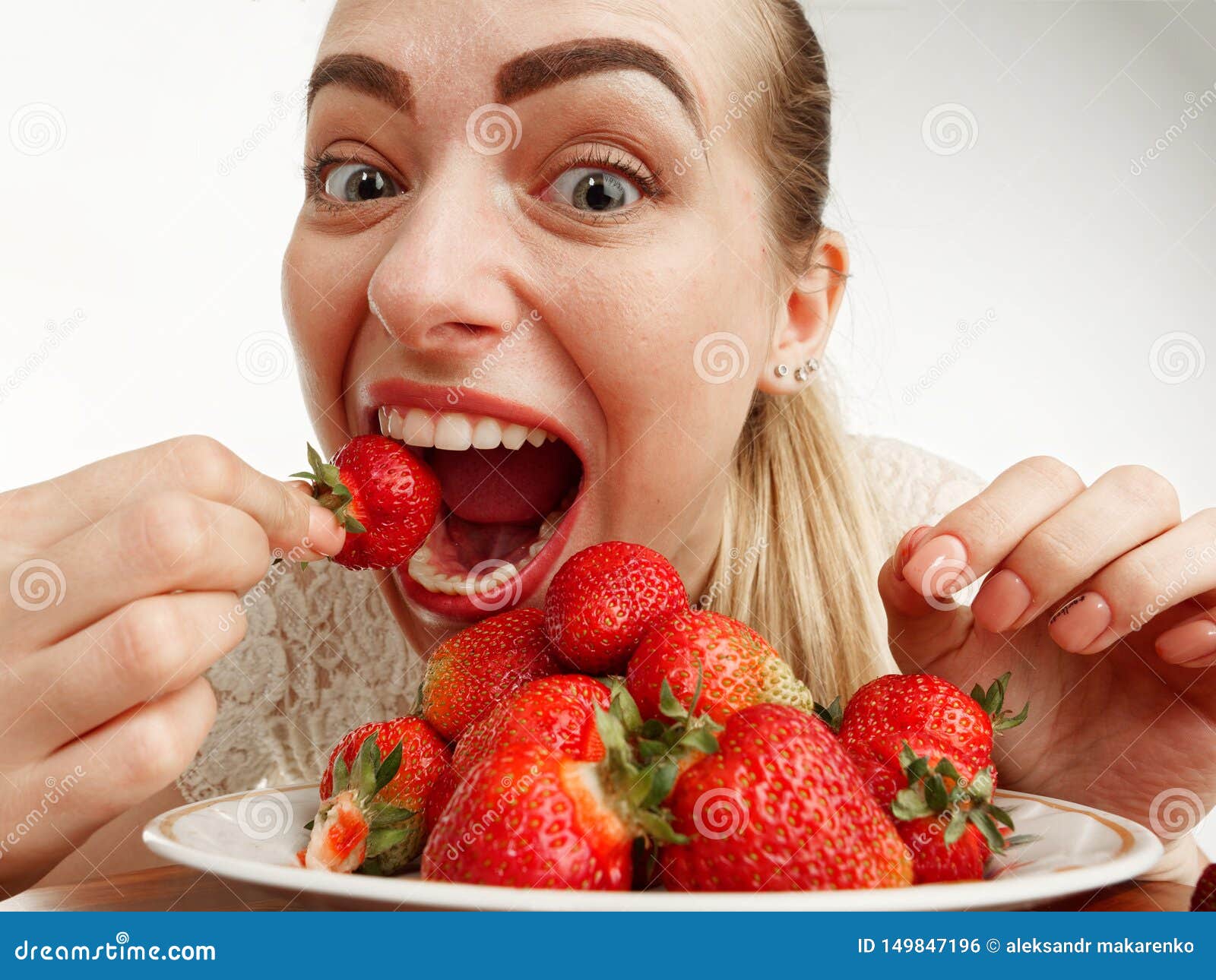 Girl Eagerly Eating Strawberries on White Background Stock Photo ...
