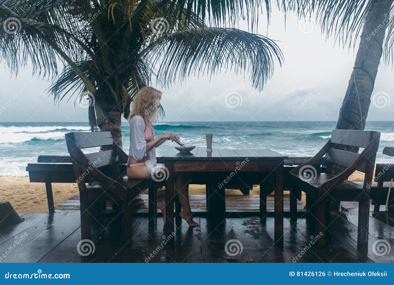 Girl eating on the beach stock photo. Image of flower - 81426126