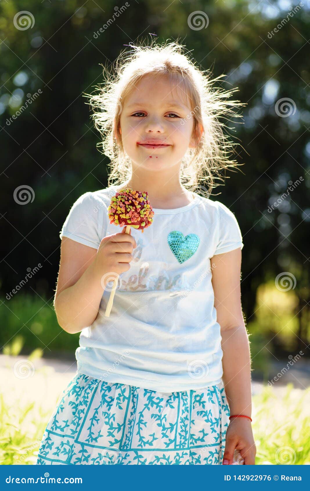 Girl eating candy apple stock photo. Image of child - 142922976
