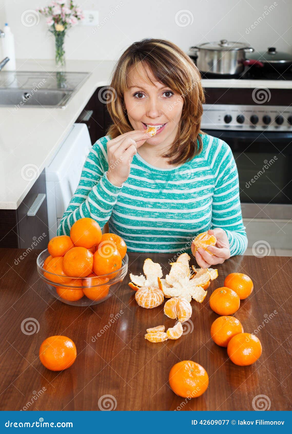Girl Eating Mandarin in Kitchen Stock Image - Image of cheerful, female ...
