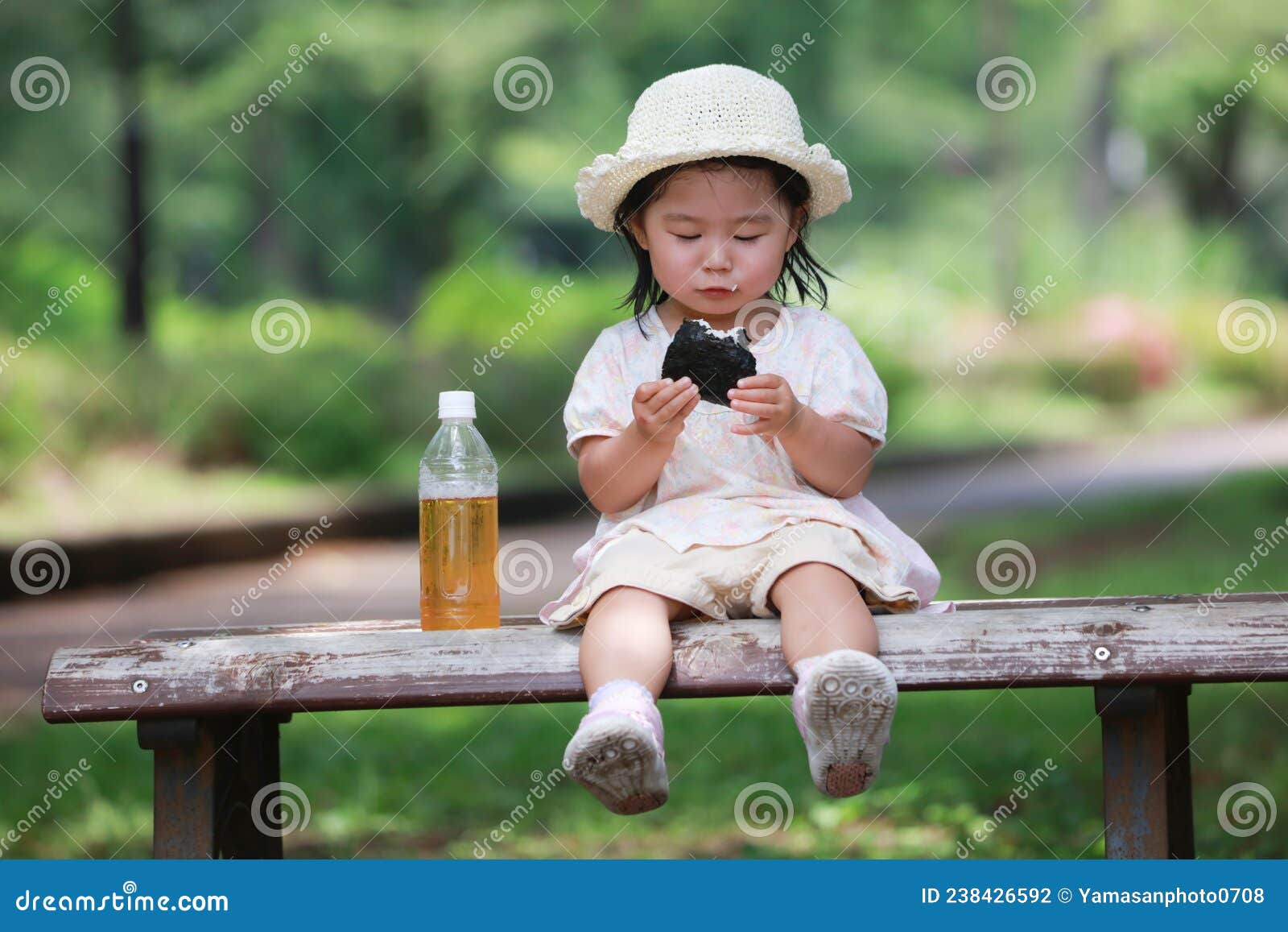 Girl eating rice balls stock photo. Image of bottles - 238426592