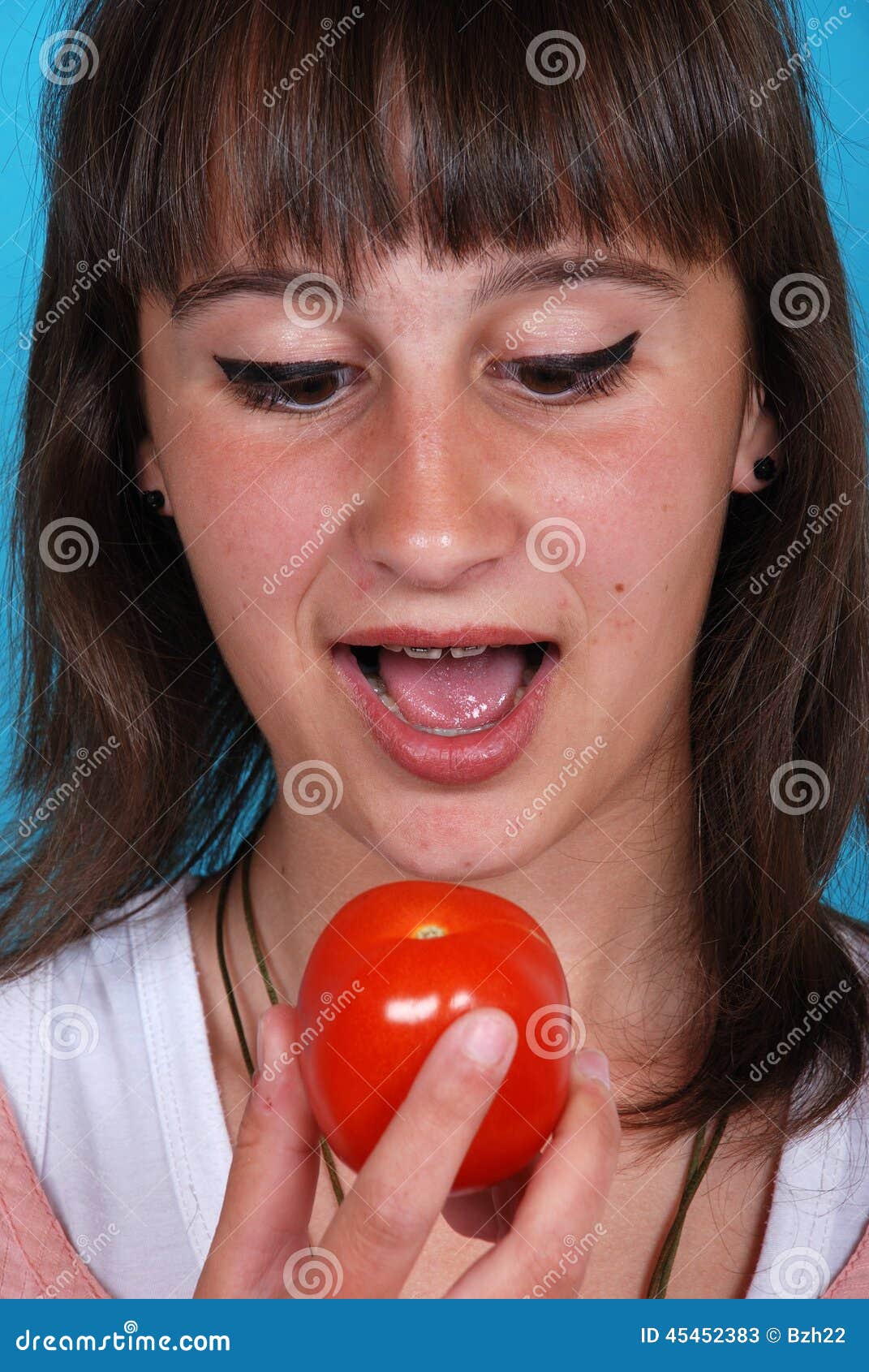 Girl eating a tomato stock image. Image of fruit, holding - 45452383