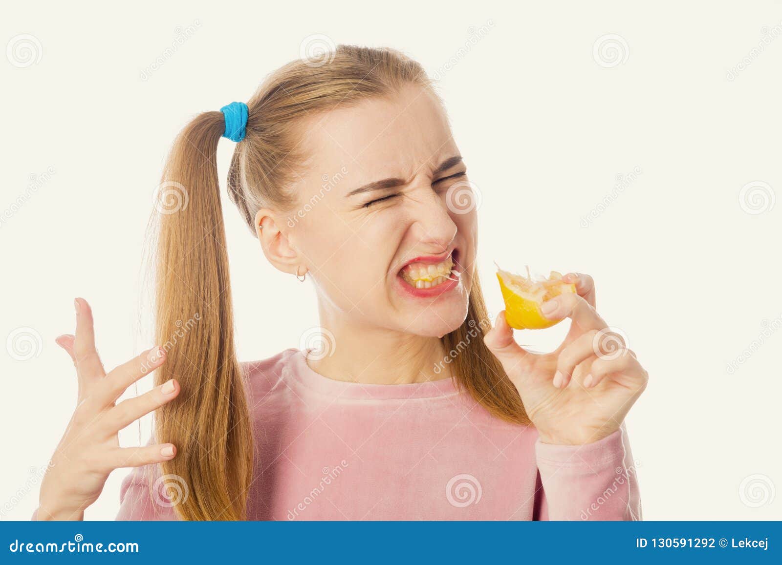 Girl eats lemon stock photo. Image of food, blond, holding - 130591292