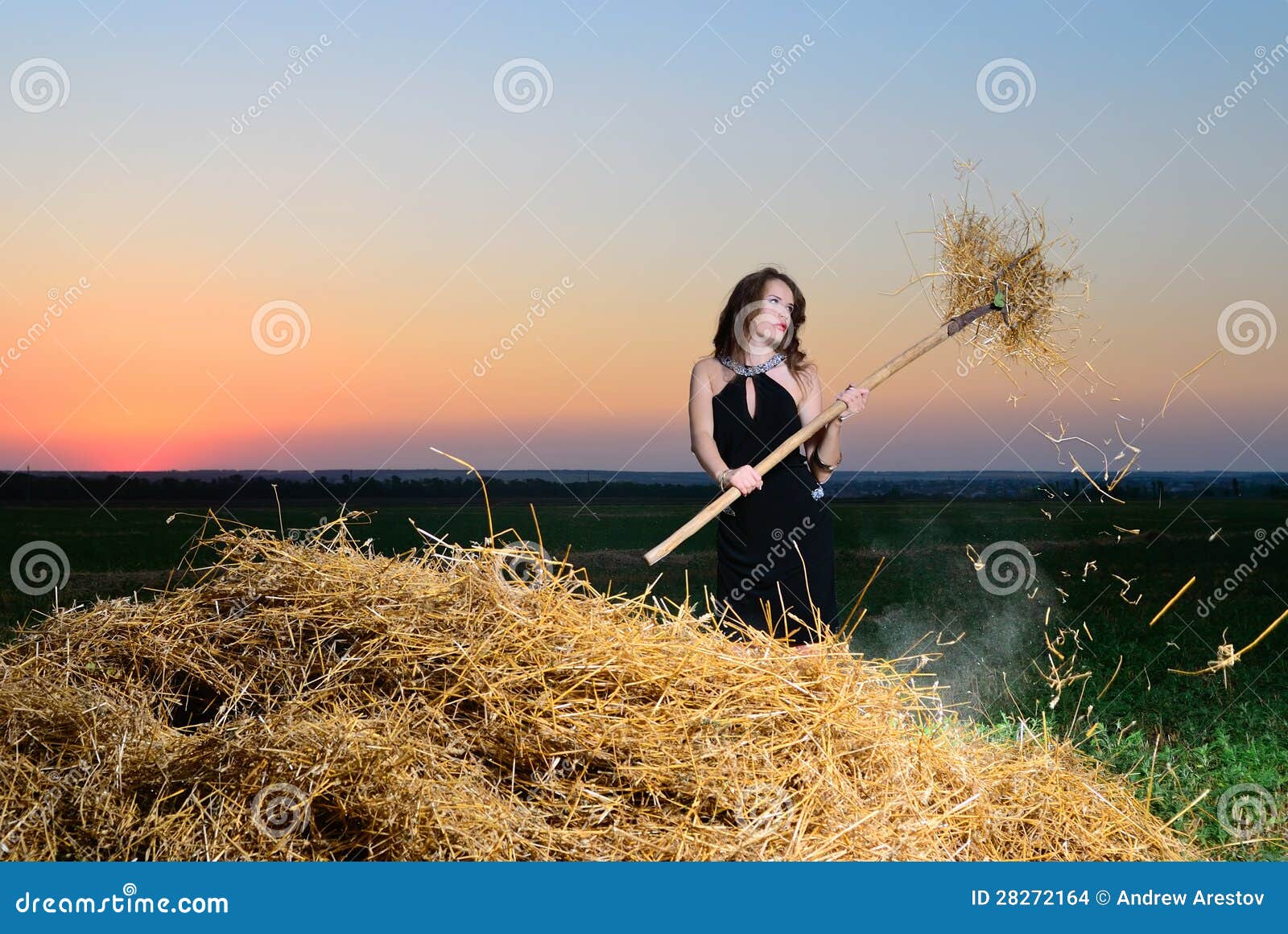 The Girl in an Evening Dress with a Pitchfork Near a Haystack Stock ...