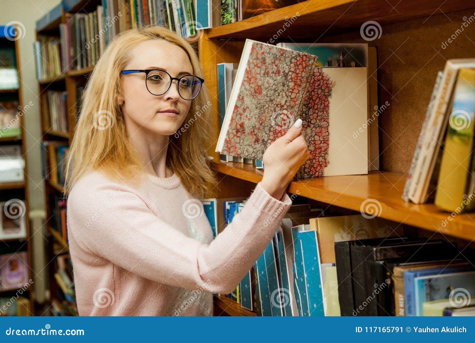 A Girl with Glasses Chooses a Book in the Library Stock Image - Image ...