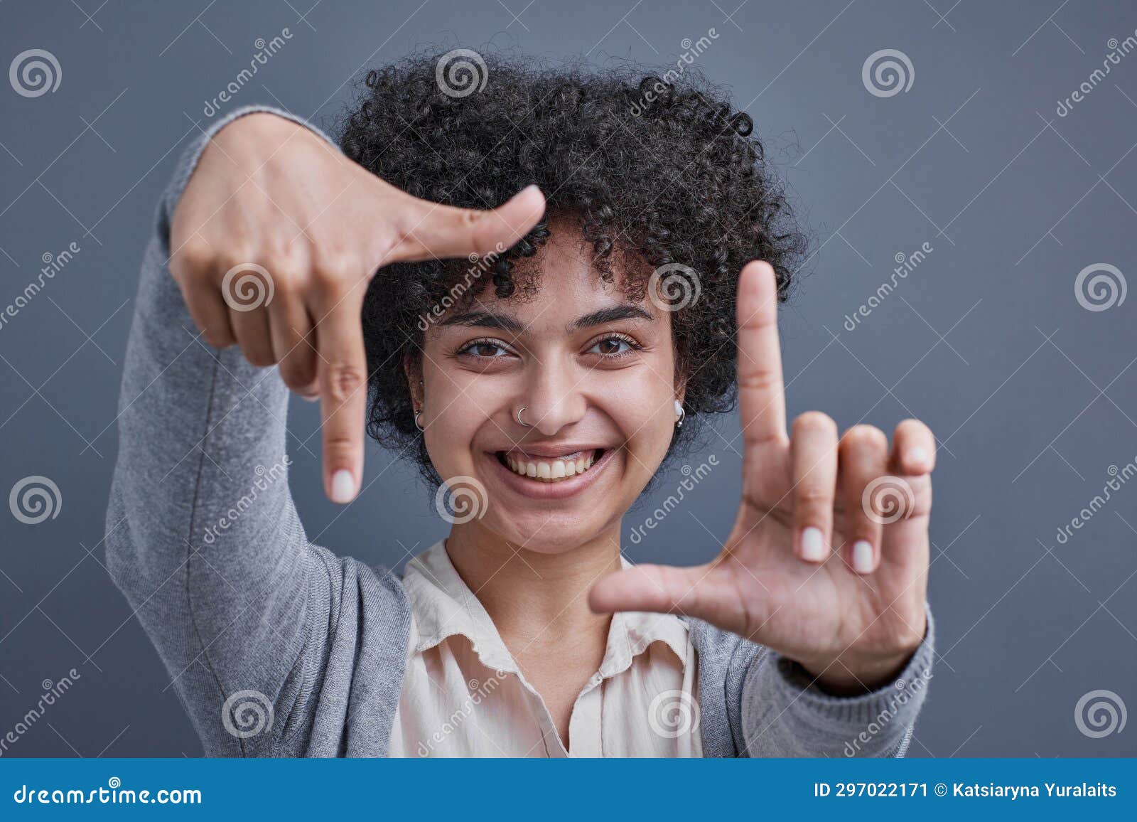 Girl on a Gray Background Smiles and Shows a Frame from Her Hands Stock ...