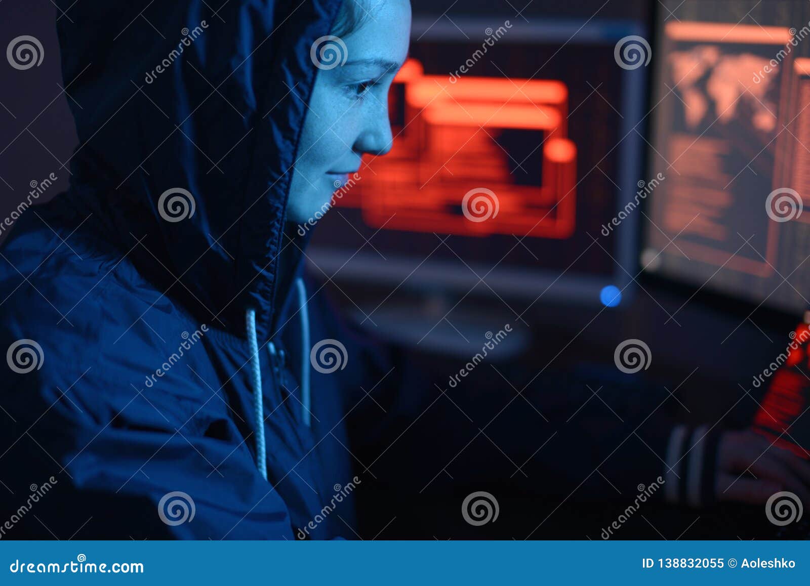Girl Hacker In A Hood Typing Program Code While Committing A Cybercrime Hacking A System On The