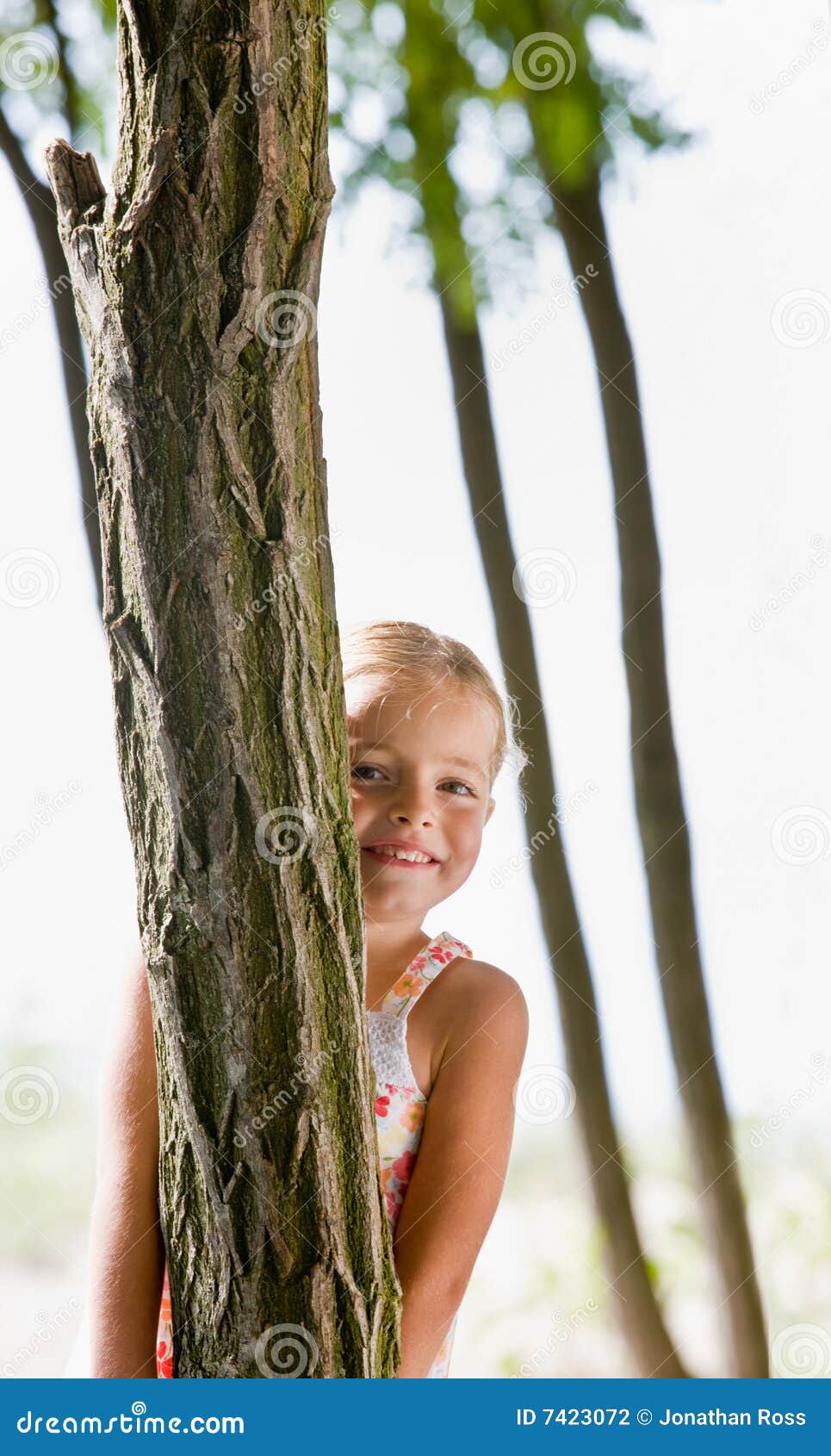 Girl hiding behind tree stock photo. Image of recreation - 7423072