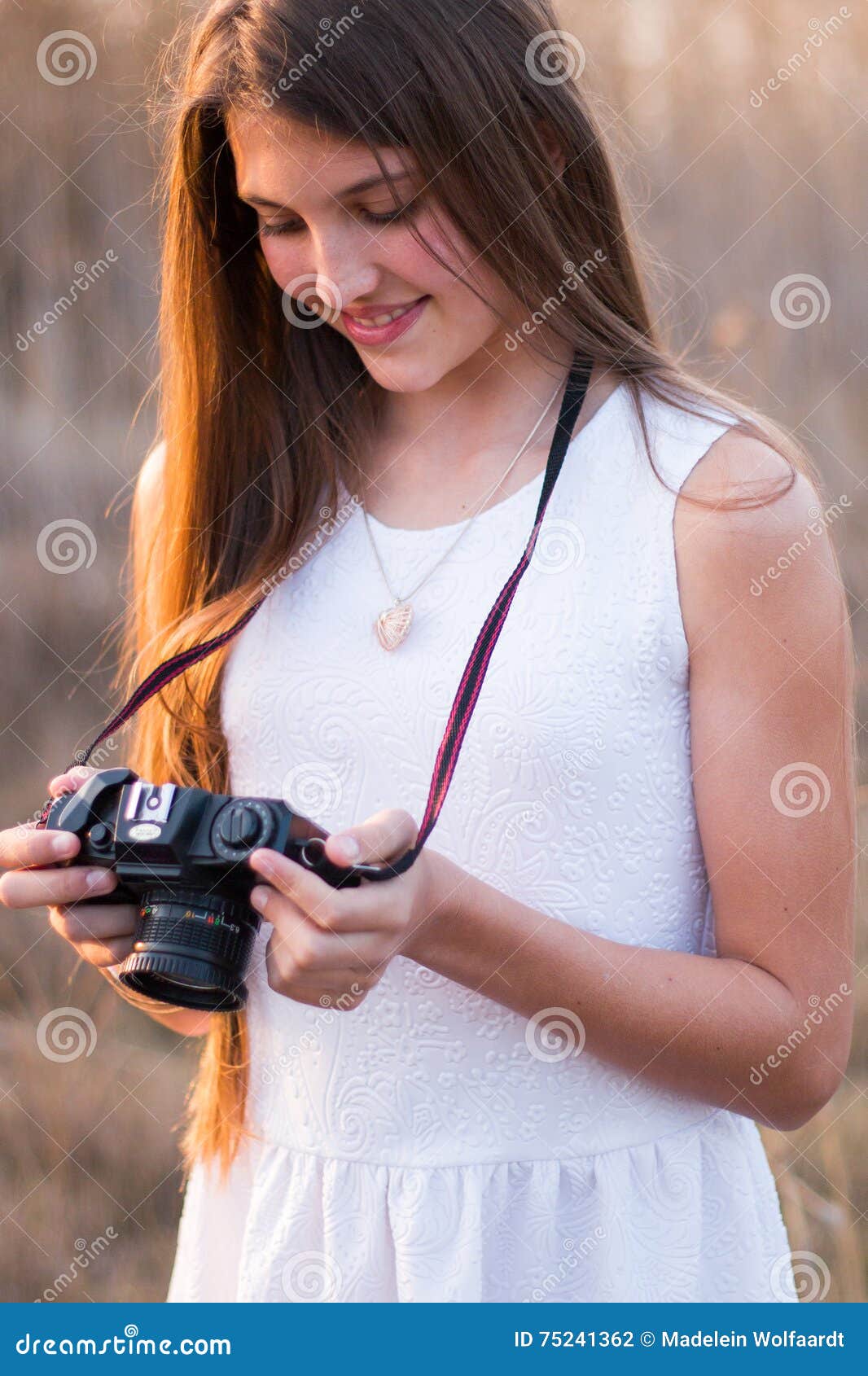 Girl Holding a Camera Looking Down Stock Photo - Image of young, woman ...