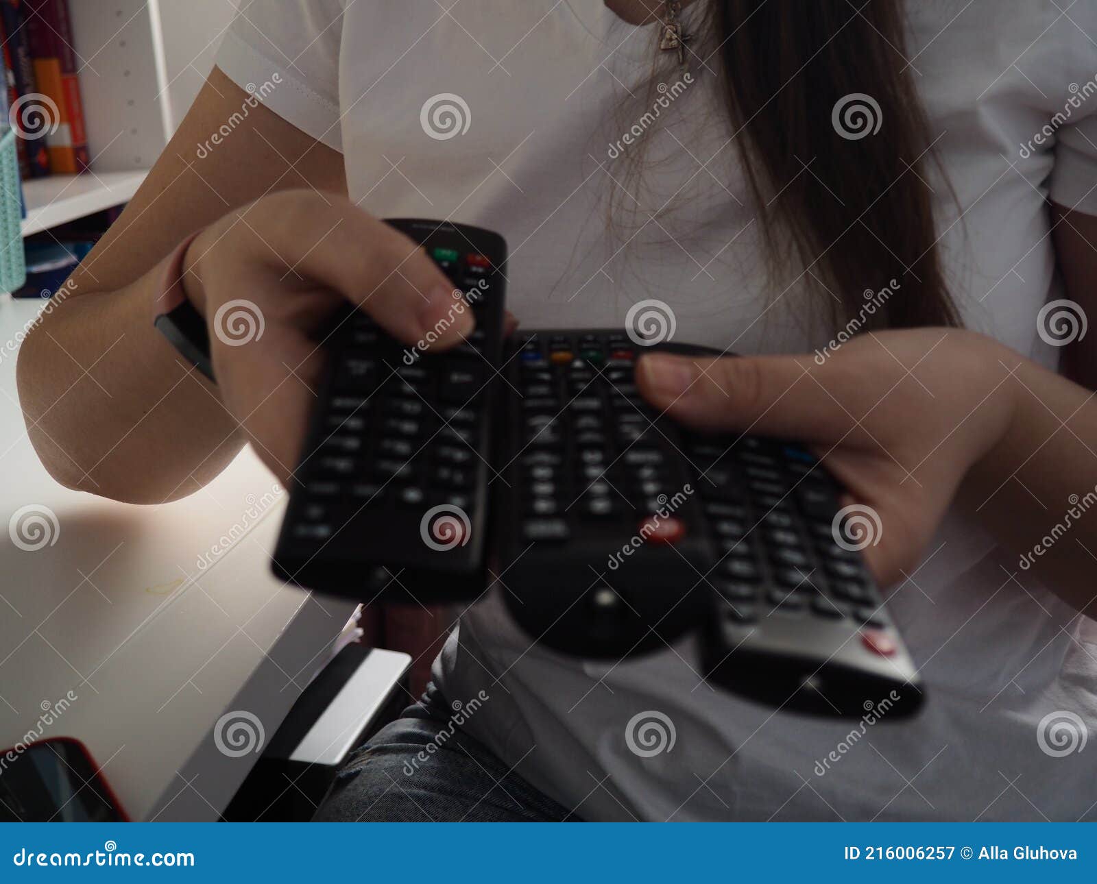 The Girl is Holding Several Remote Controls from the TV Stock Image ...