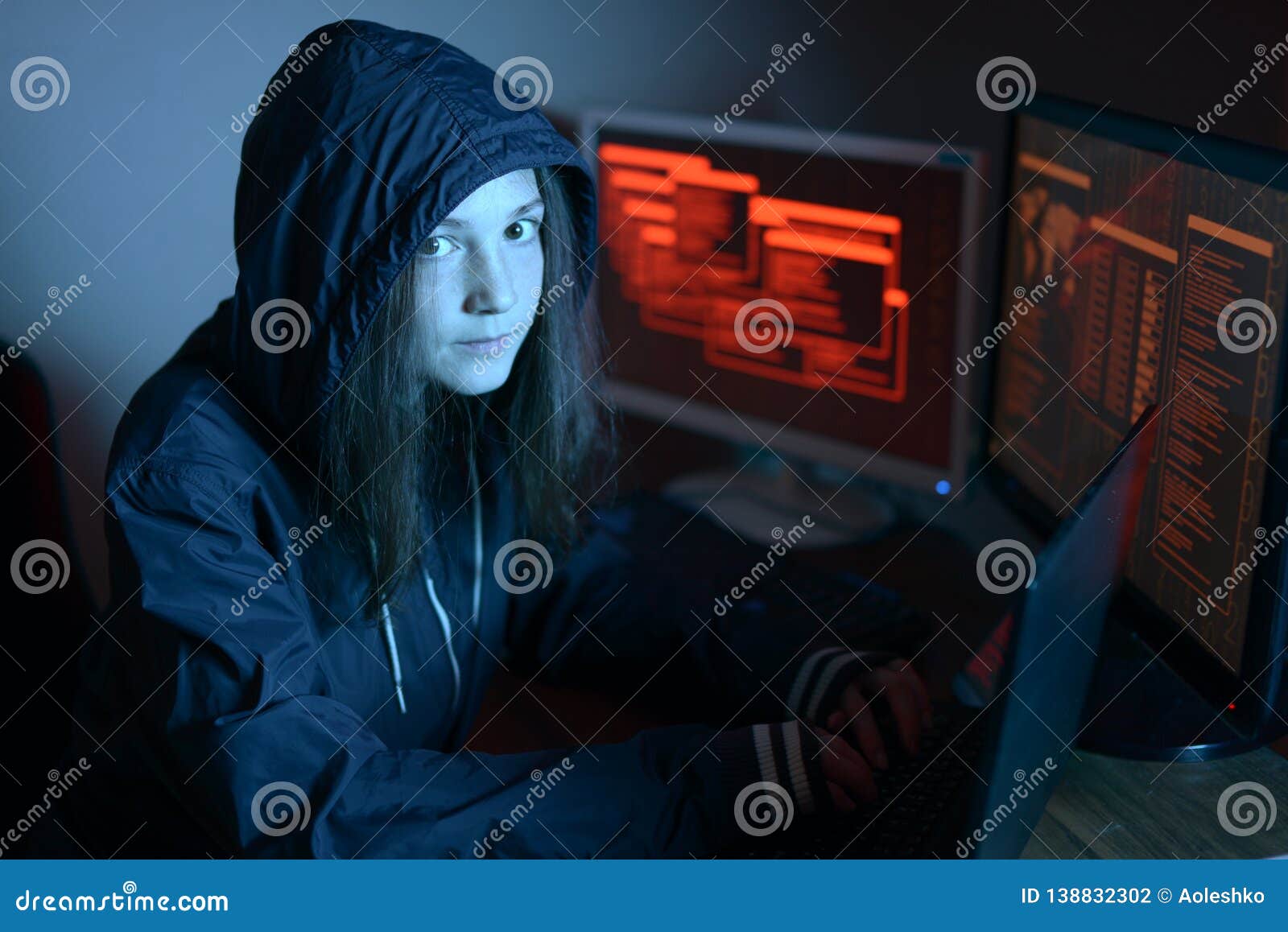 Girl In The Hood Looking In The Camera Hacker Attacks And Online Fraud On The Screen Background