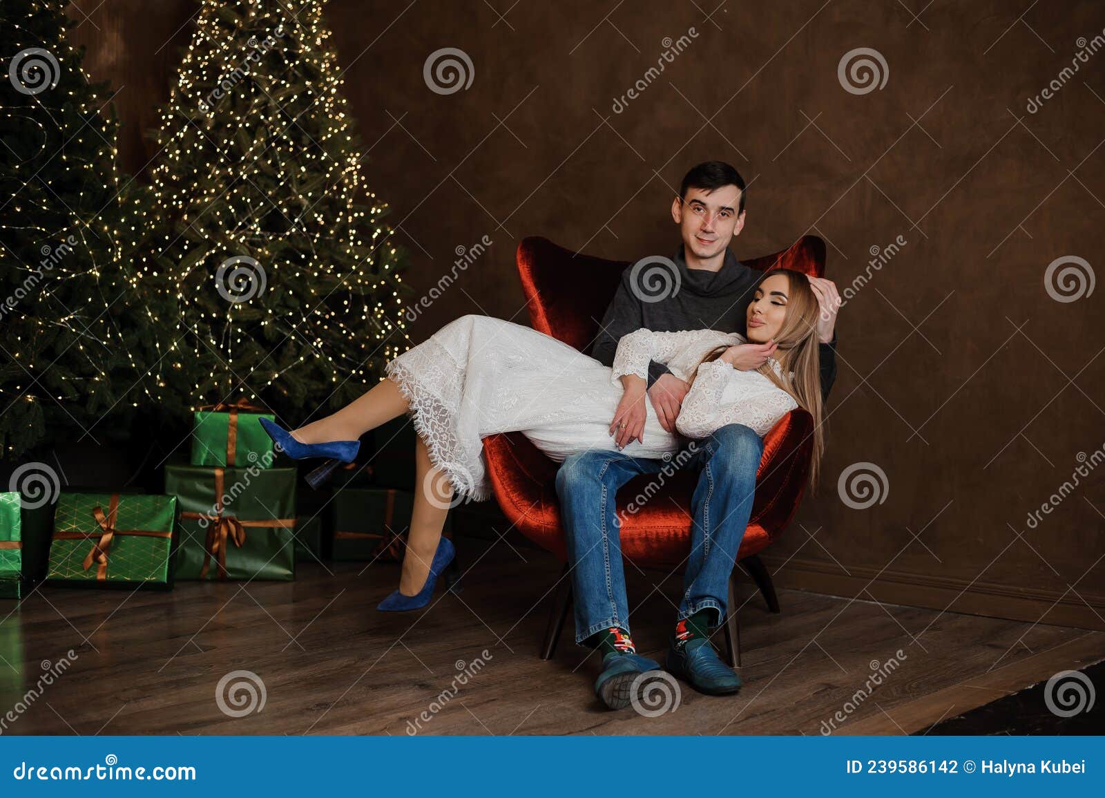 Girl Hugging a Guy Sitting on a Red Chair Stock Photo - Image of model ...
